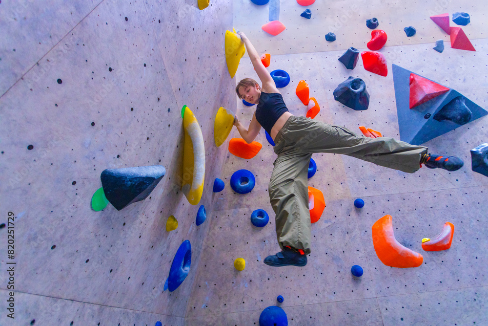 Bouldering climbing athlete woman training at indoor gym boulder climb ...