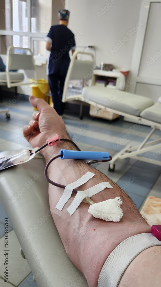Blood donor during blood donation, transfusion. Close-up of a man's ...