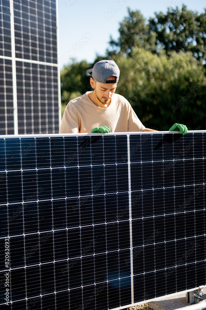 Man installing solar panels on a roof of his house, fitting cell on ...