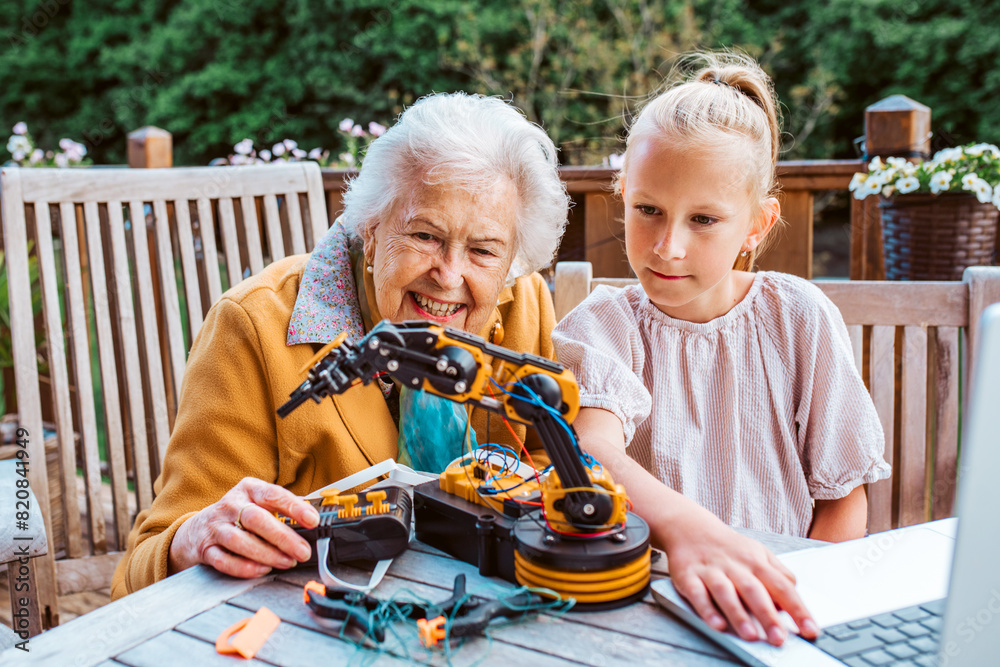 Grandmother supporting granddaughter in robotics, science, IT ...