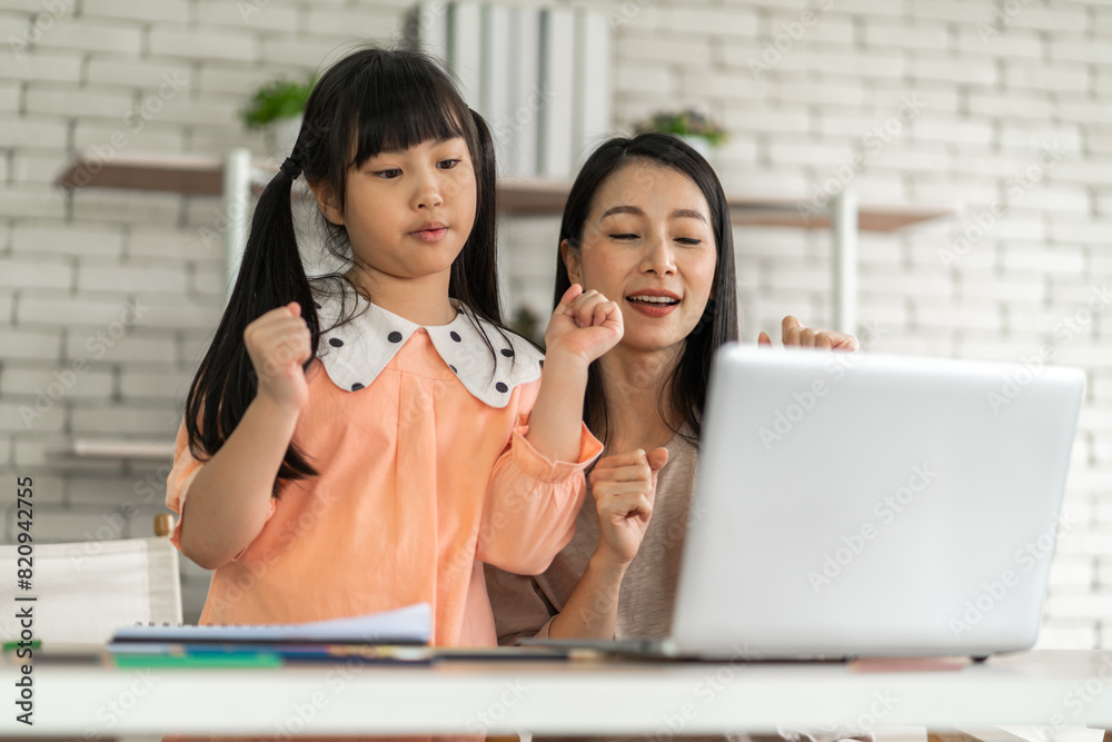 Mother and asian kid little girl learn and look at laptop computer ...