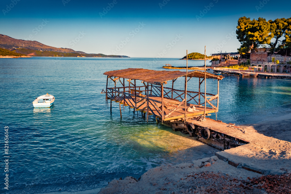Sunny summer view of Ksamil resort with old wooden pier. Bright ...