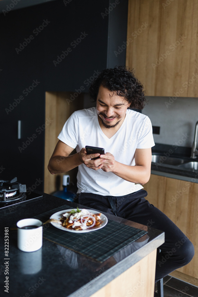 latin man eating chilaquiles for mexican breakfast at home in Mexico ...