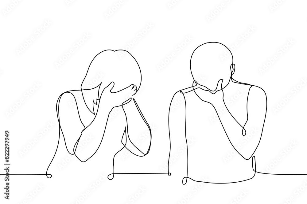 man and a woman stand next to each other, covering their faces with ...