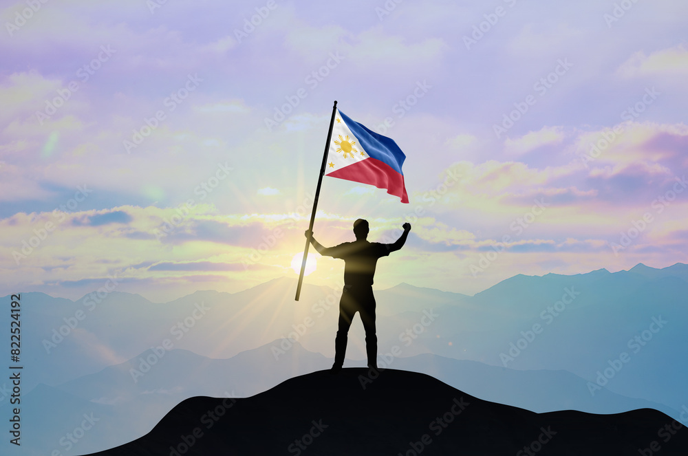 Philippines flag being waved by a man celebrating success at the top of ...
