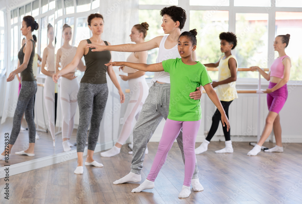 Focused African American teenage girl carefully practicing ballet moves ...