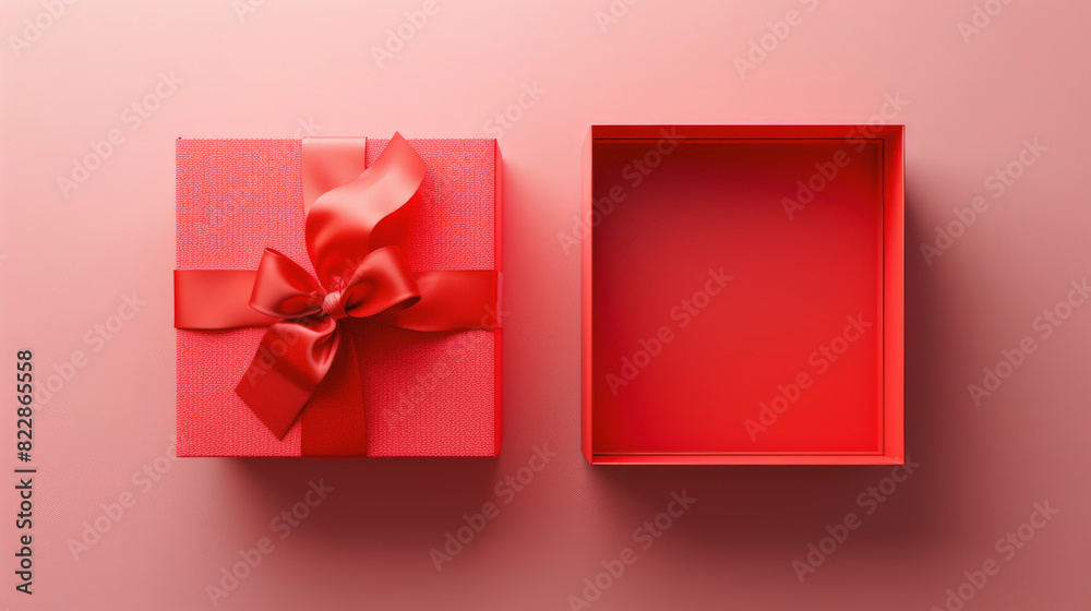 A red gift box with a bow next to an open, empty red box on a pinkish ...