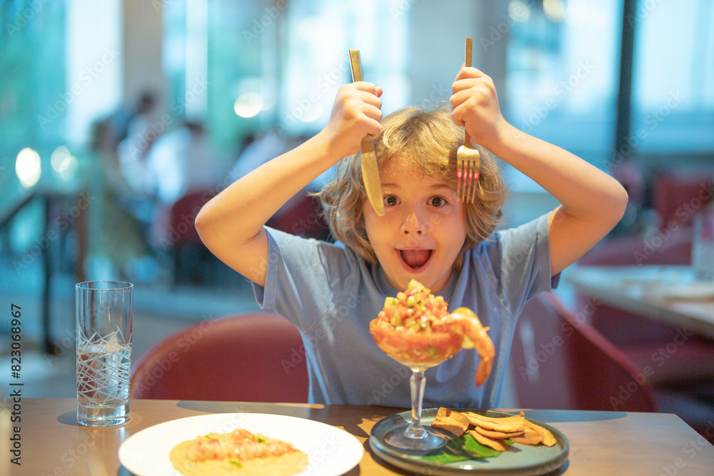 Funny surprised Little boy eating seafood in cafe. Kid eat Food fish ...