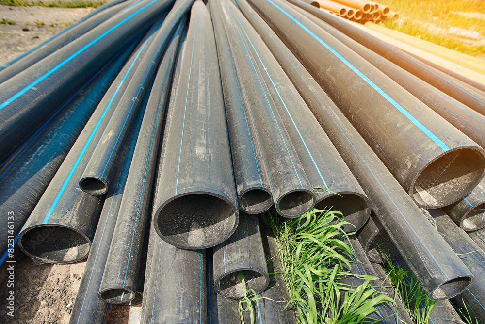 Polyethylene pipes stacked on the ground. Black pipe for new water ...