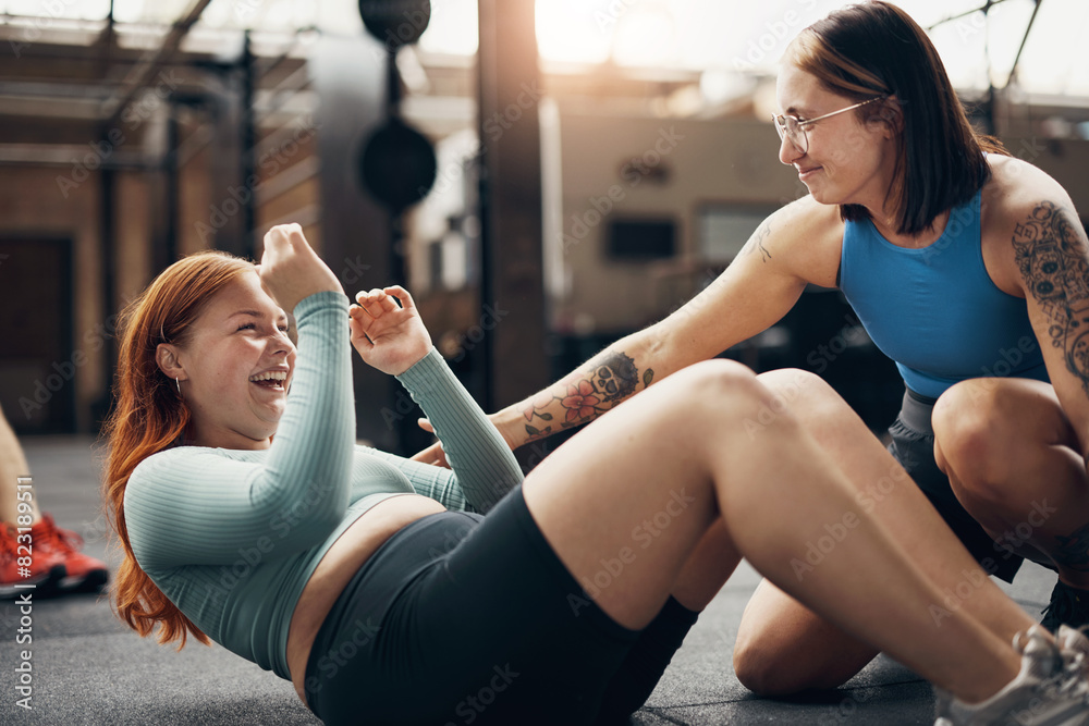 Laughing woman getting encouragement from a partner during a sit-ups ...