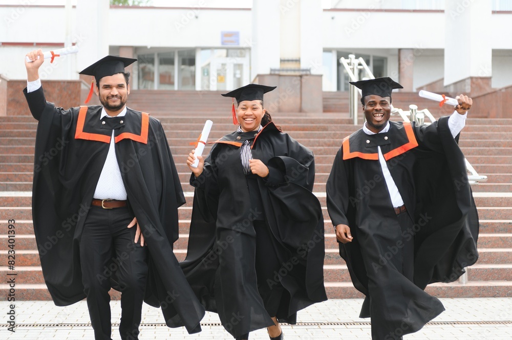 Group of happy smiling multicultural people in graduation gowns and ...
