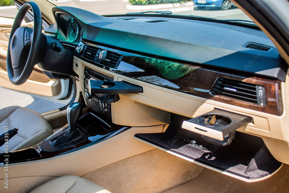 Black and beige dashboard and steering wheel of a car with an open ...