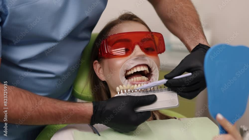 Teeth shades, Dental procedure, Dental visit. Patient holds hand mirror ...