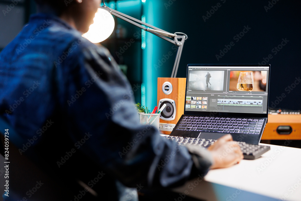 African American woman edits film footage on her laptop, creating ...