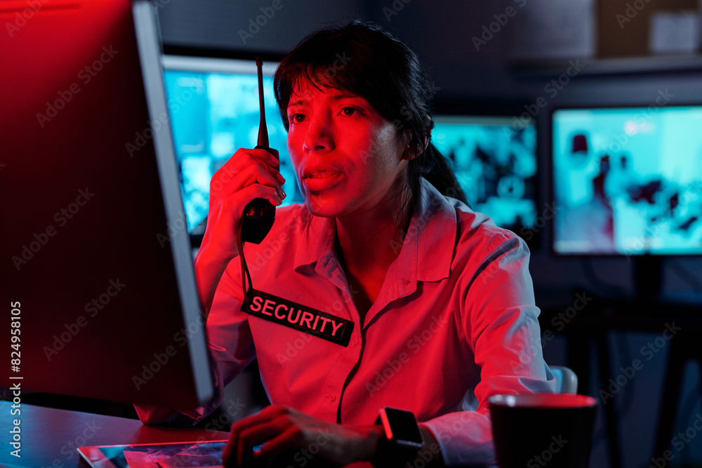 Neon light falling on young female officer in uniform looking at ...