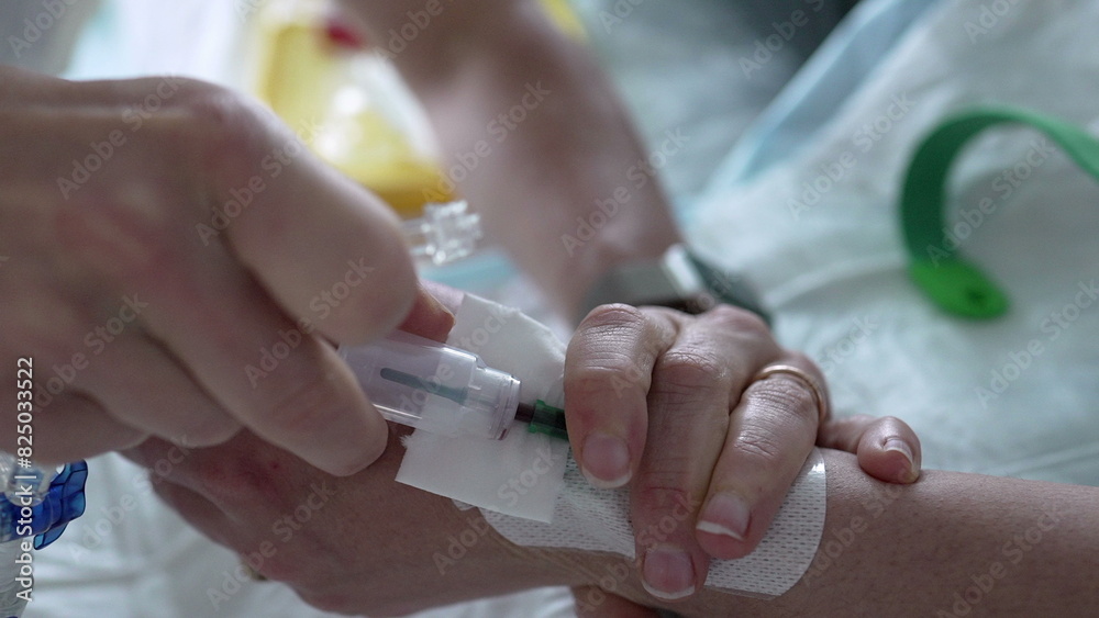 Nurse hand applying medical drip into Patient's hand with IV catheter ...