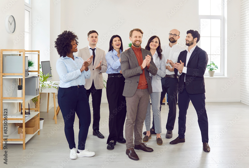 Group of company employees congratulating their happy male colleague on ...