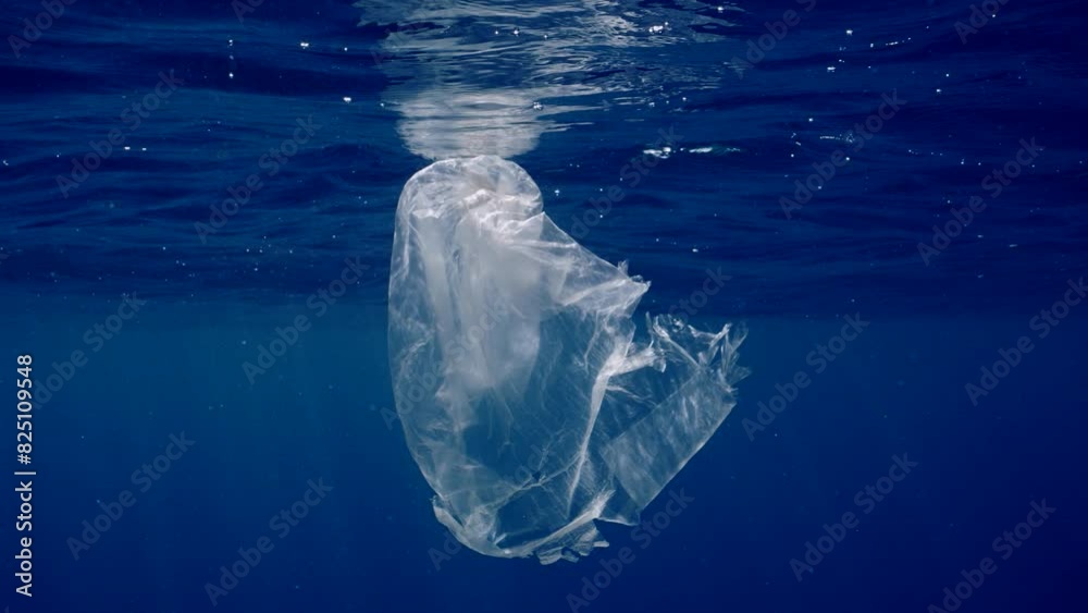 Plastic bag underwater with sun rays under waves of water, Slow motion ...