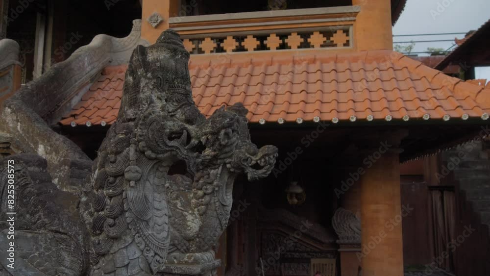 Detailed footage of a traditional Balinese stone dragon statue in front ...