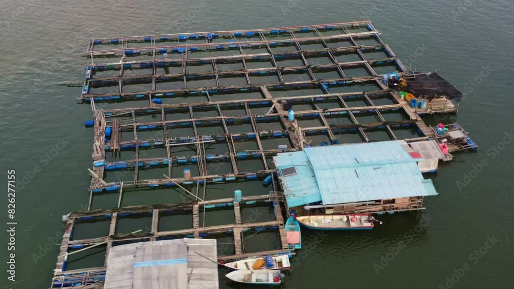 Drone low flyover and around a traditional floating fish farms on calm ...