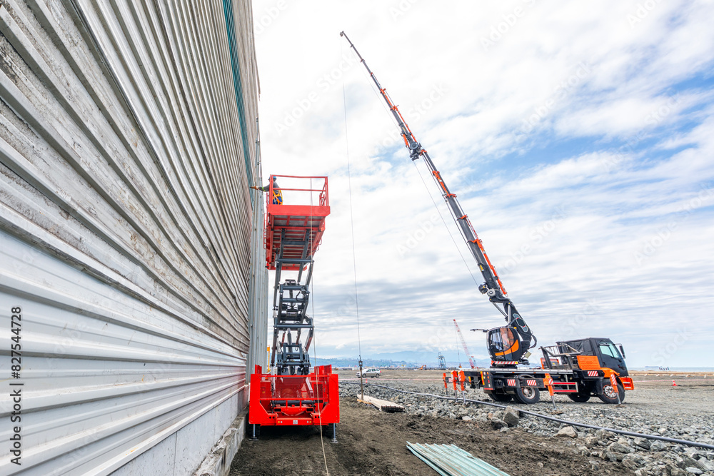 Worker is working for exterior cladding of factory on the scissor ...