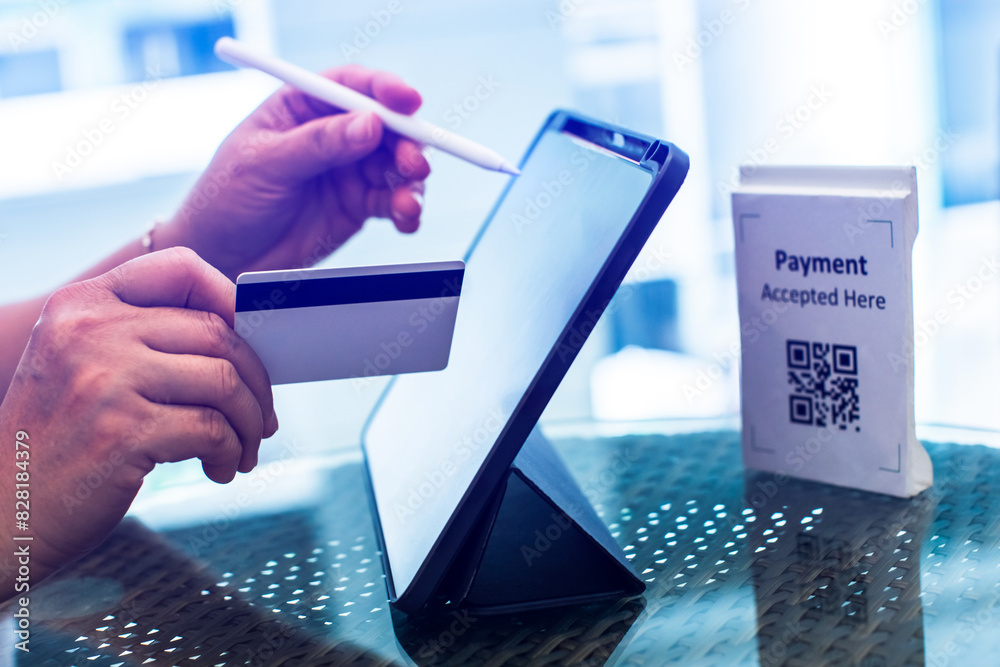 Cashier staff using tablet to receive orders from customers at counter ...