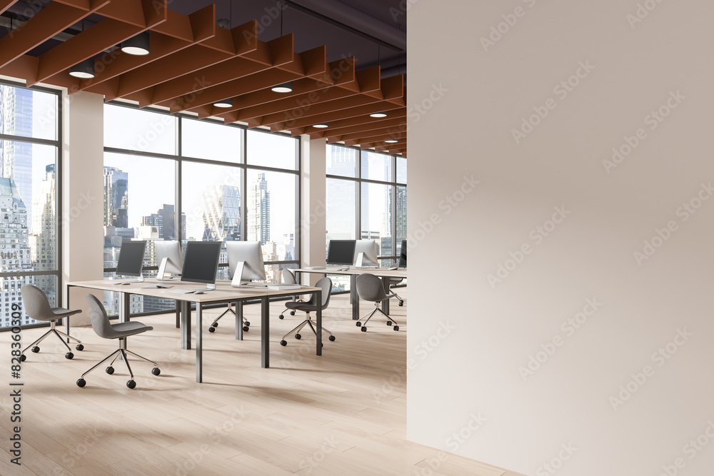 Modern office space with computers on desks, in front of large windows ...