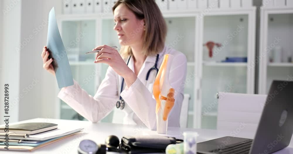 Doctor shows anatomy of knee joint and x-ray. Arthrosis of knee joint ...