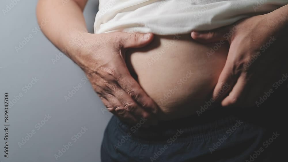 Man pointing own unhealthy big belly with visceral or subcutaneous fats ...
