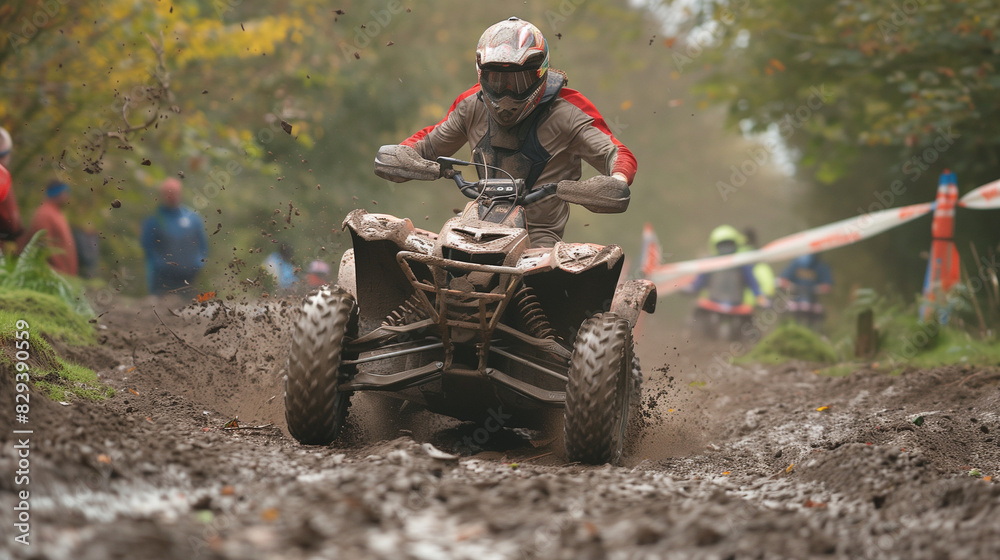 On a muddy race track, a quad covered in mud fights for victory. The ...