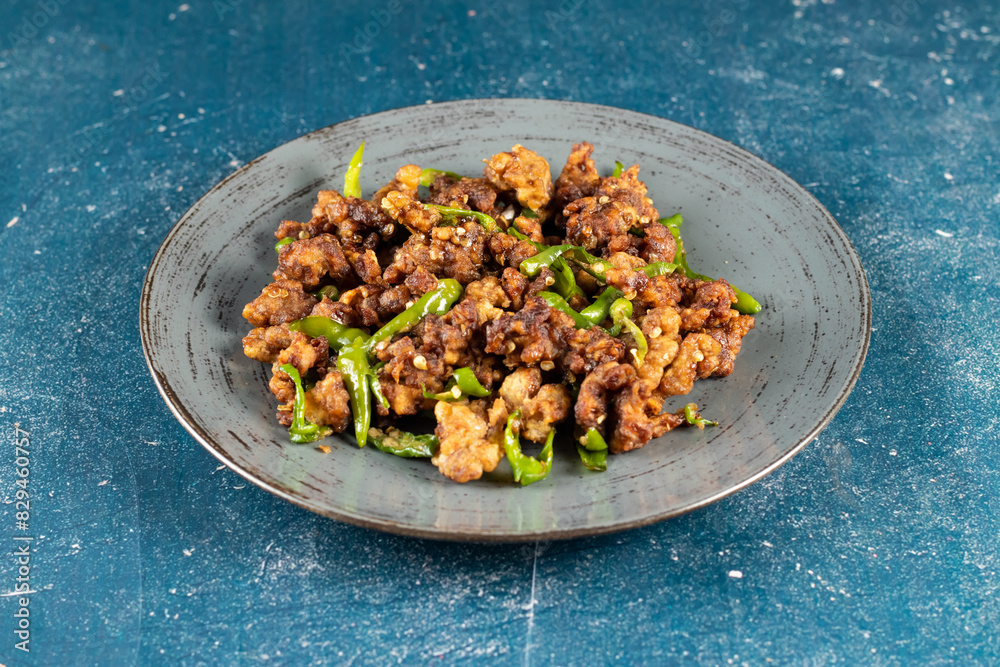 Stir Fried Green Chilli Chicken Dry served in plate isolated on navy ...