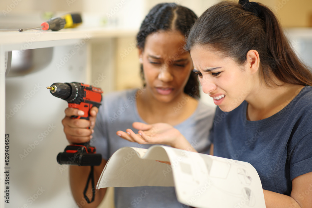 Confused women reforming house reading instruction manual Stock Photo ...