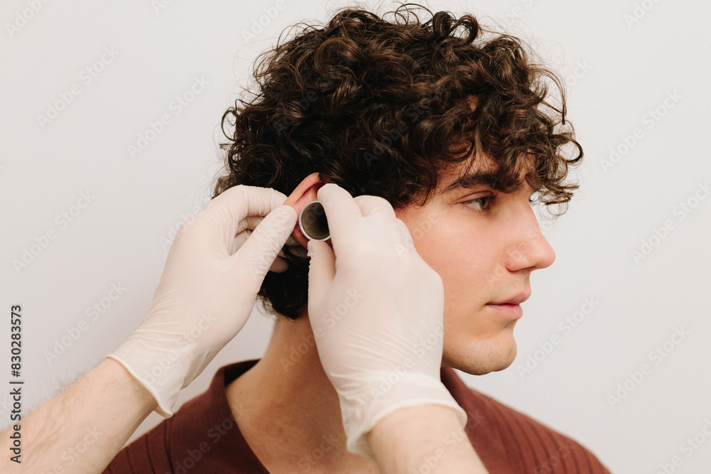 Ent doctor examine ear of patient with ear funnel. Checking the outer ...
