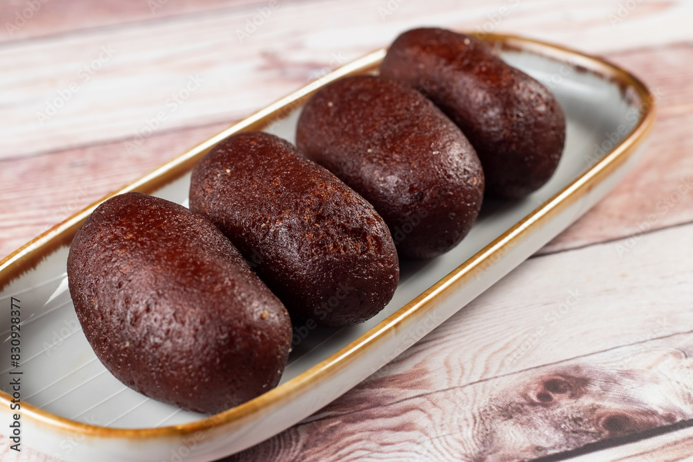 Gulab Jamun, kalo jam or mohan served in tray dish isolated on wooden ...