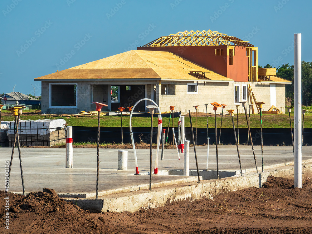 Concrete foundation with utility connections (white conduits) and ...