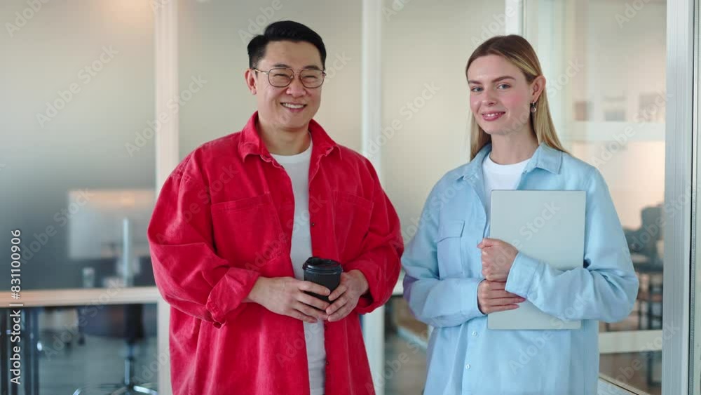 Captivating woman holding wireless laptop and dashing man clad in ...