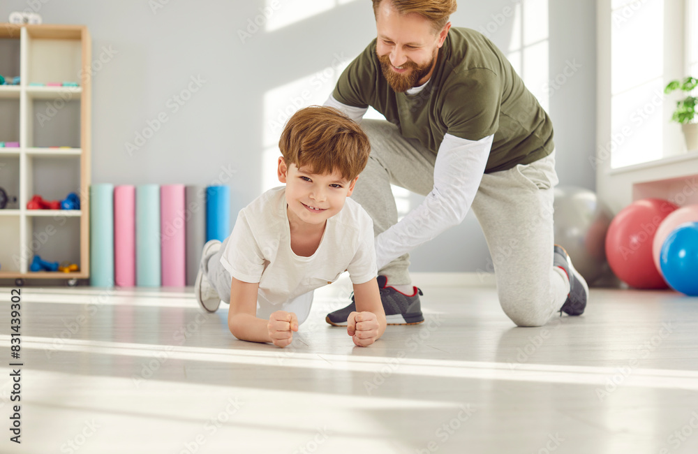 Child concentrates on holding plank position. Dad trains his preteen ...