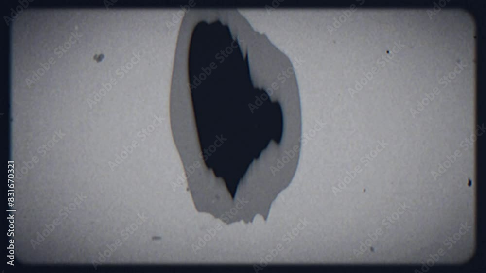 Black and white old style film frame with blurry blob shapes in motion ...