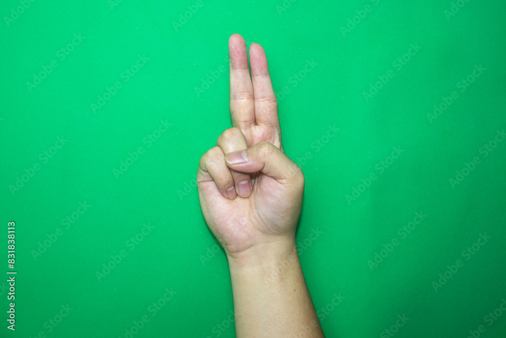 hand showing sign, sign language of alphabet of U, on green background ...