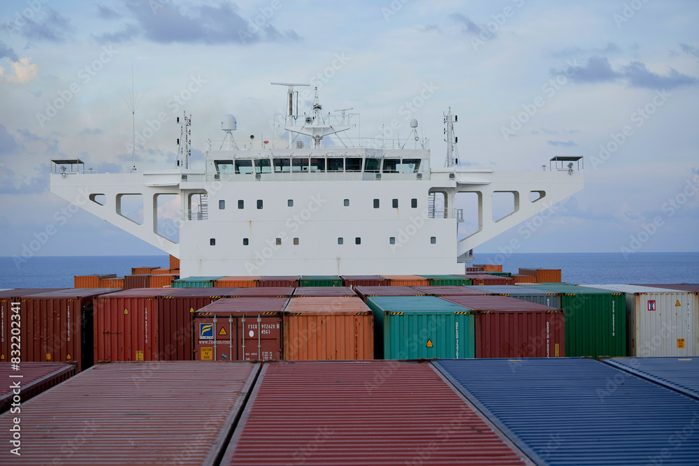 A large cargo ship loaded with colorful shipping containers is seen ...