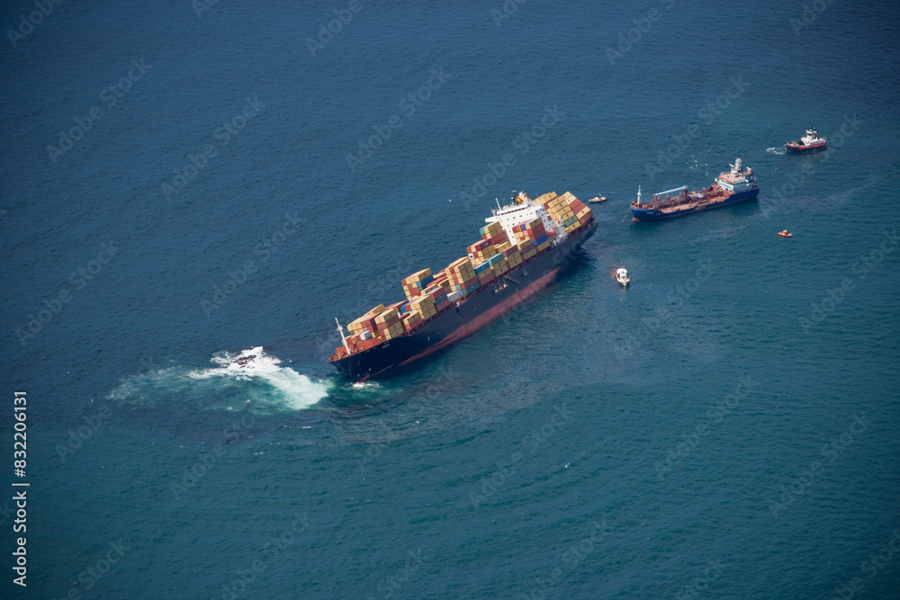 An aerial view of a large cargo ship in trouble at sea, being ...