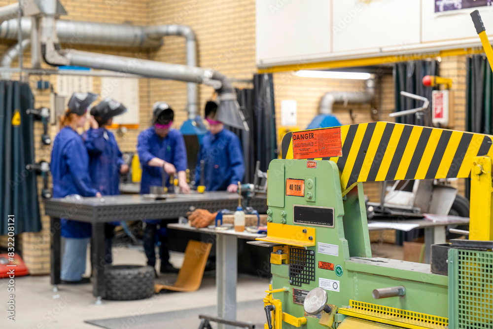 Workers in blue uniforms are focused on their tasks at different ...