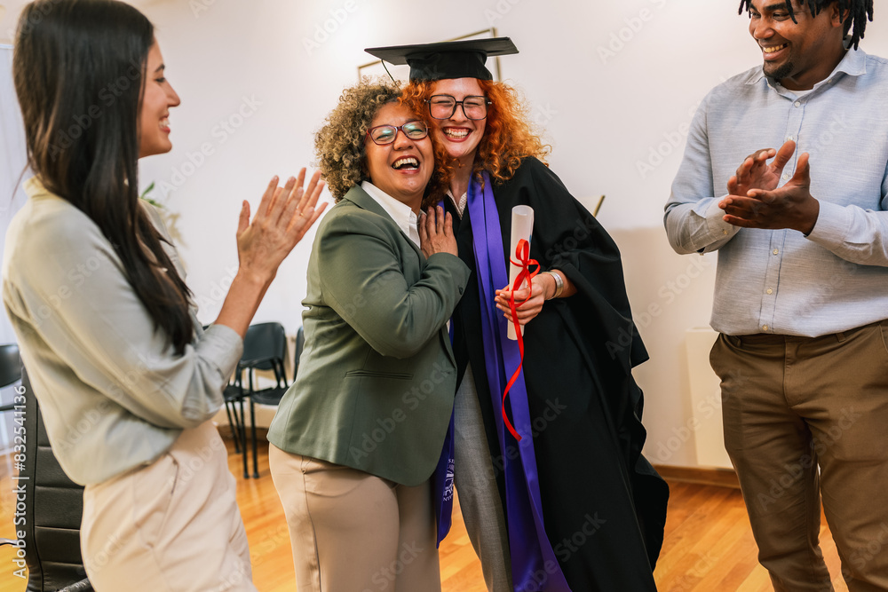 Ginger graduate student celebrating graduation in toga with her family ...