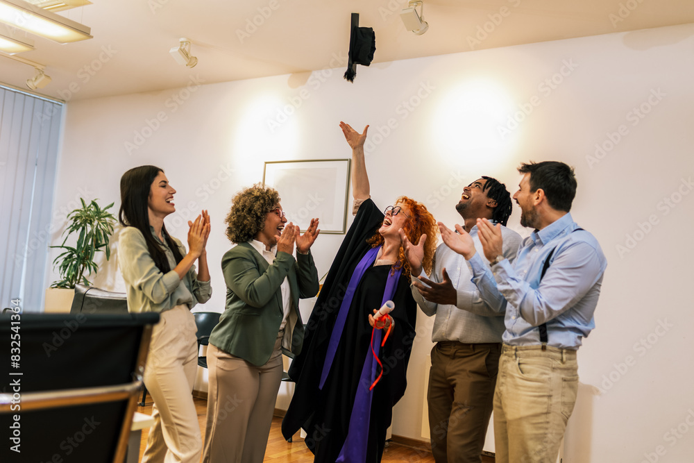 Ginger graduate student celebrating graduation in toga with her family ...