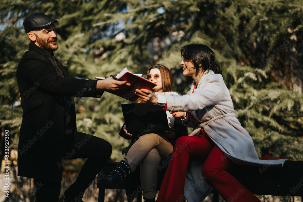 Dynamic young entrepreneurs engage in an outdoor brainstorming session ...