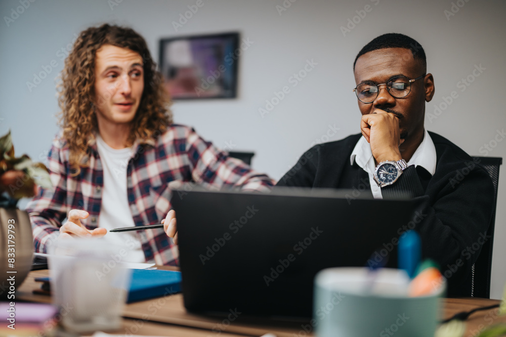 Two male office workers intensely discussing project ideas in a casual ...
