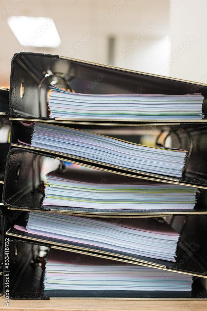 Files stacked on filing cabinet. A large pile of binders filled with ...