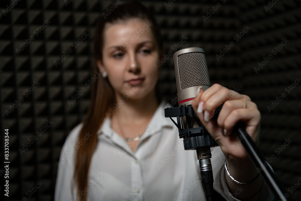 Young singer stands poised studio before microphone in the acoustic ...