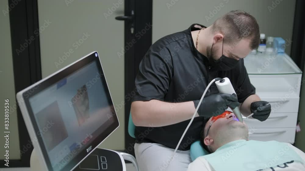 Doctor scans the patient's teeth in the clinic. The dentist holds in ...