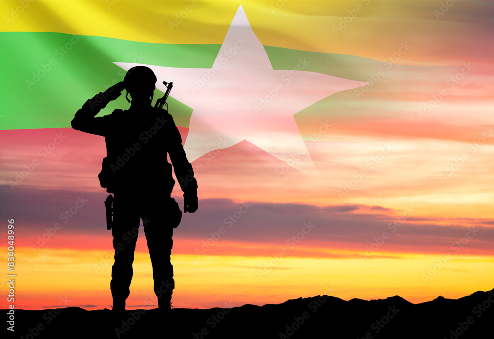 Silhouette of a soldier with Myanmar flag against the sunset. Armed ...